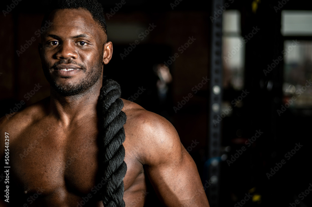 Muscular african american man posing with rope in gym. Stock Photo ...