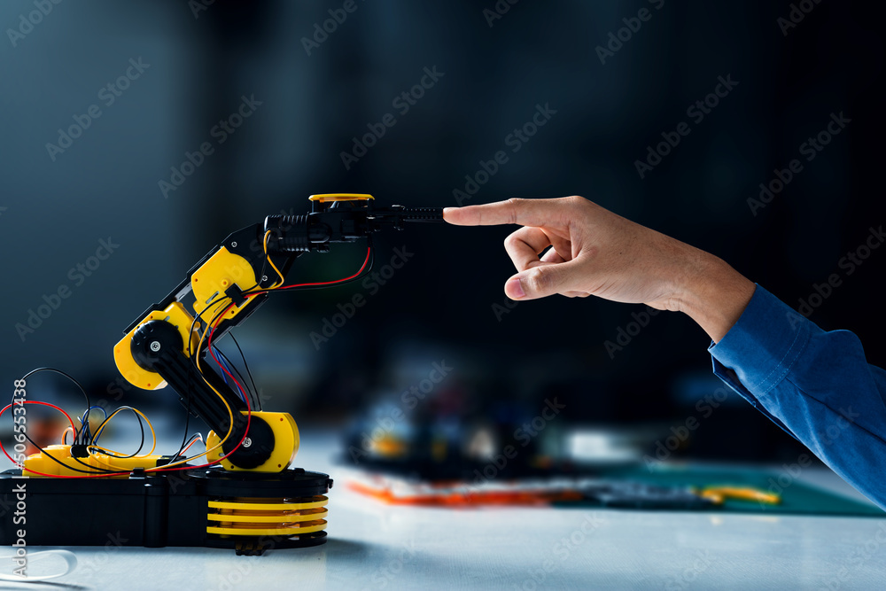 Robot arm touches human hand in science classroom. robotics programing ...