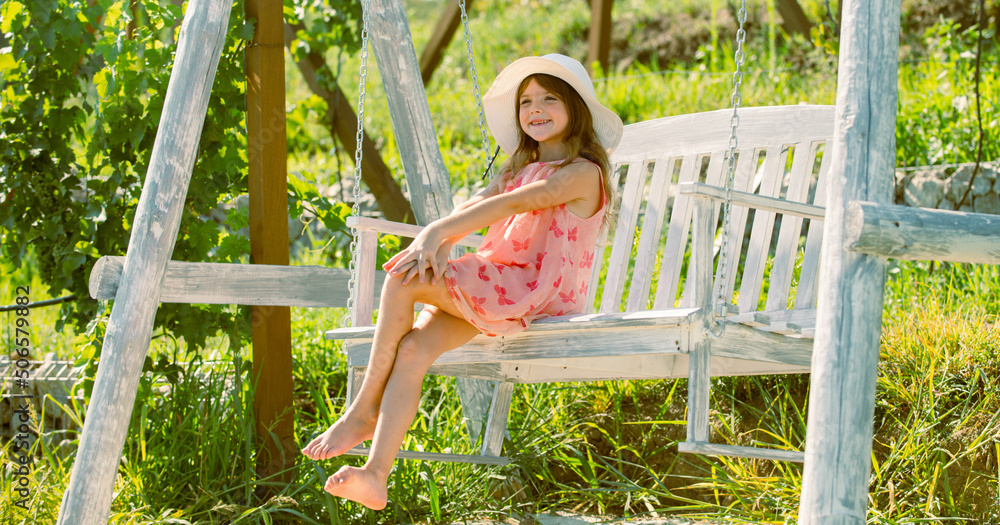 Happy little child girl on a swing in the summer park. Beautiful child ...