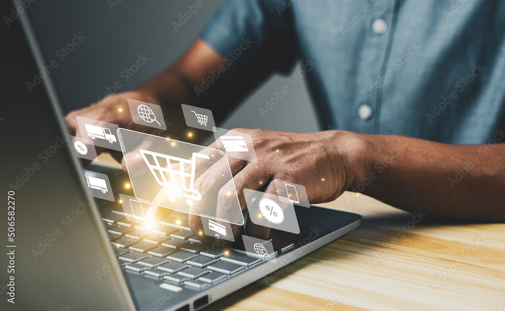 Shopper using computer laptop to input order with trolley credit card ...