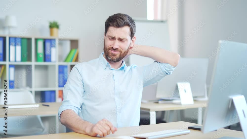 Handsome caucasian male employee with pain in the muscles of the neck ...