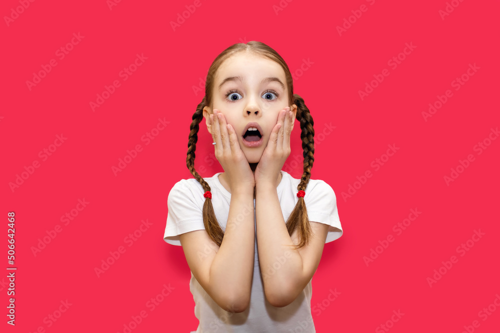 Girl child with pigtails on a red background with a surprised look ...