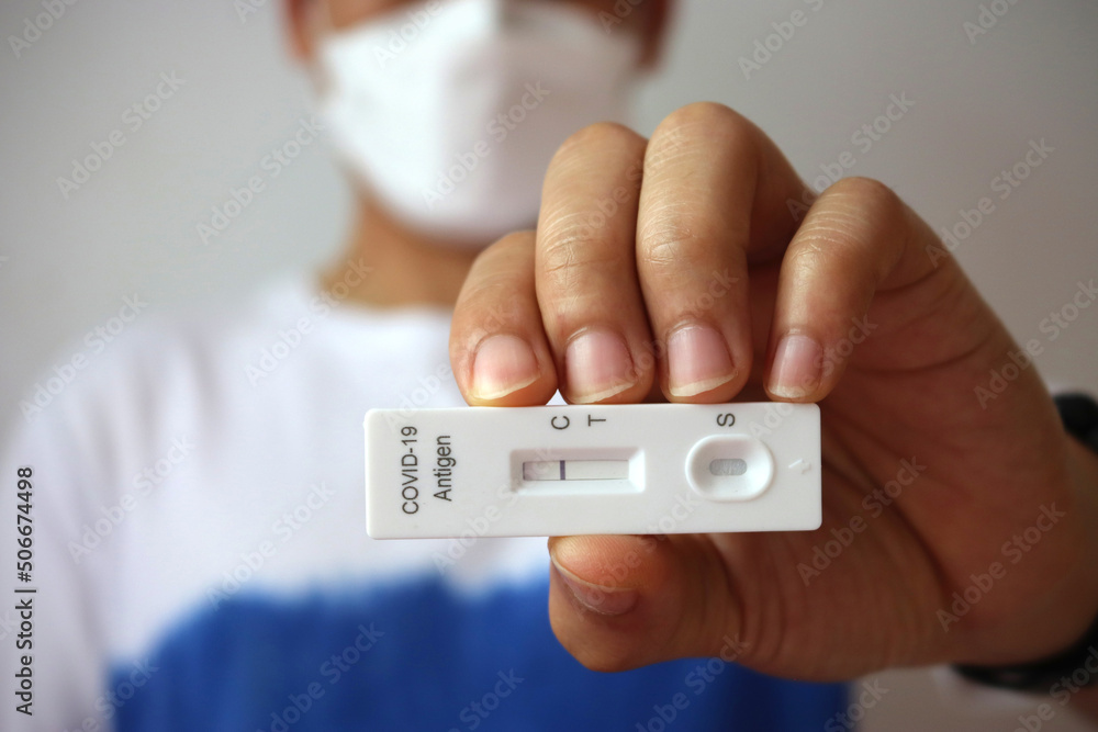Man holding Rapid Antigen Test kit with Negative result during swab ...