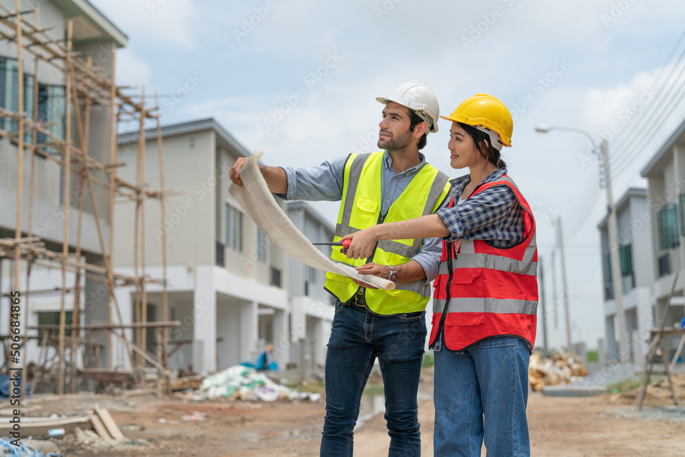 Asian female civil engineer and caucasian male architect wears safety ...