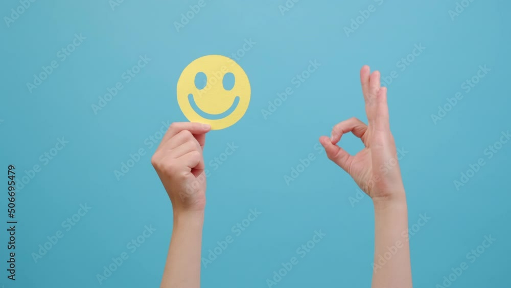 Female hand holding yellow happy smile face, good feedback rating and ...