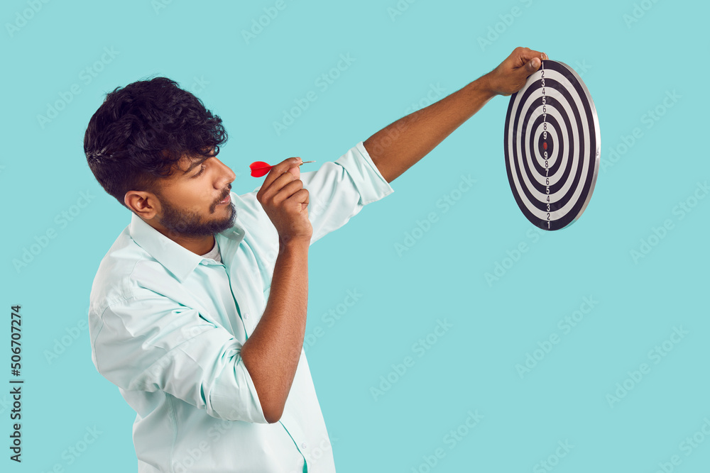 Indian man shooting at target. Profile view of young South Asian man in ...