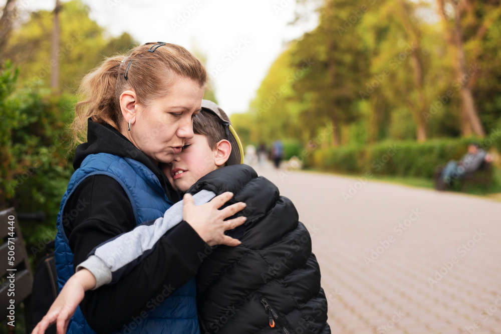 Mom hugs her little son, soothes him, caress his back, the boy fell in ...