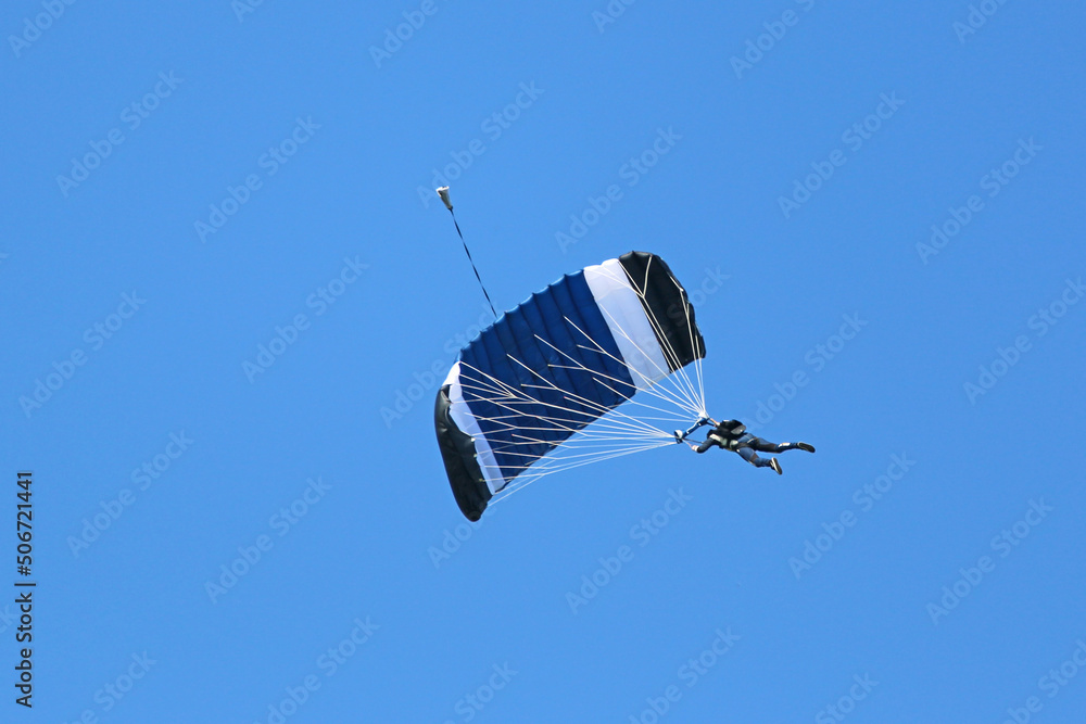 Skydiver flying wing in a blue sky Stock Photo | Adobe Stock
