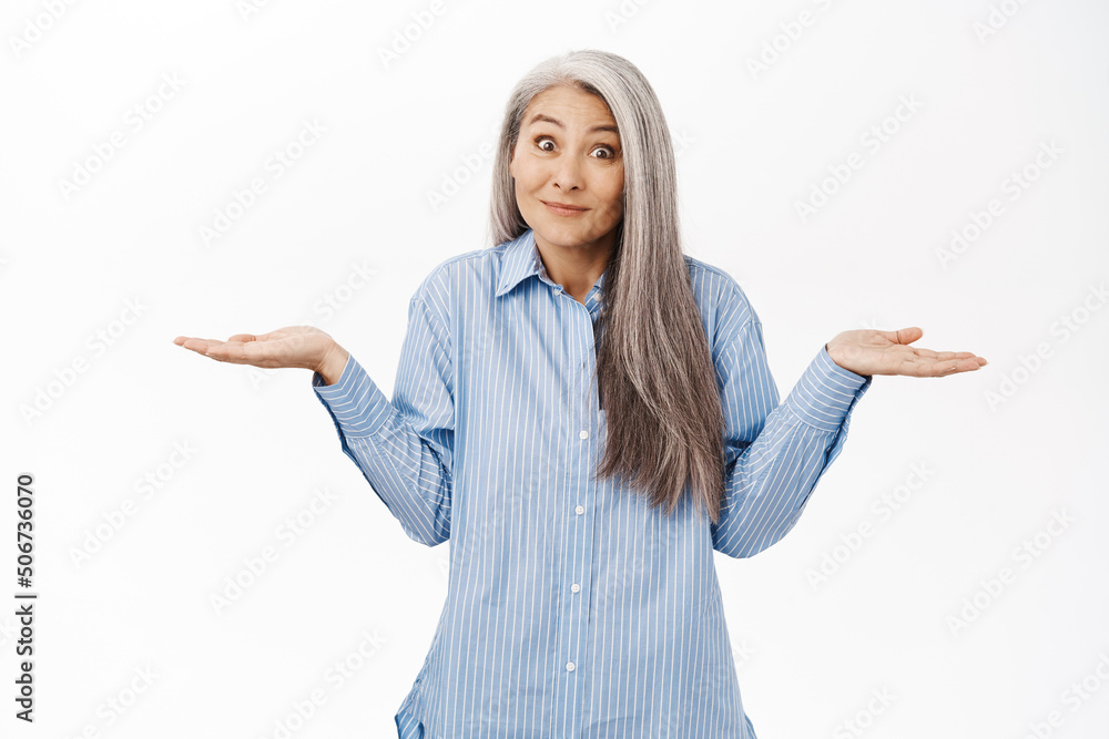 Dont know. Clueless asian lady shrugging shoulders and smiling. Senior ...