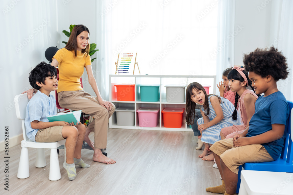 Caucasian beautiful woman teacher doing activity with kids at school ...