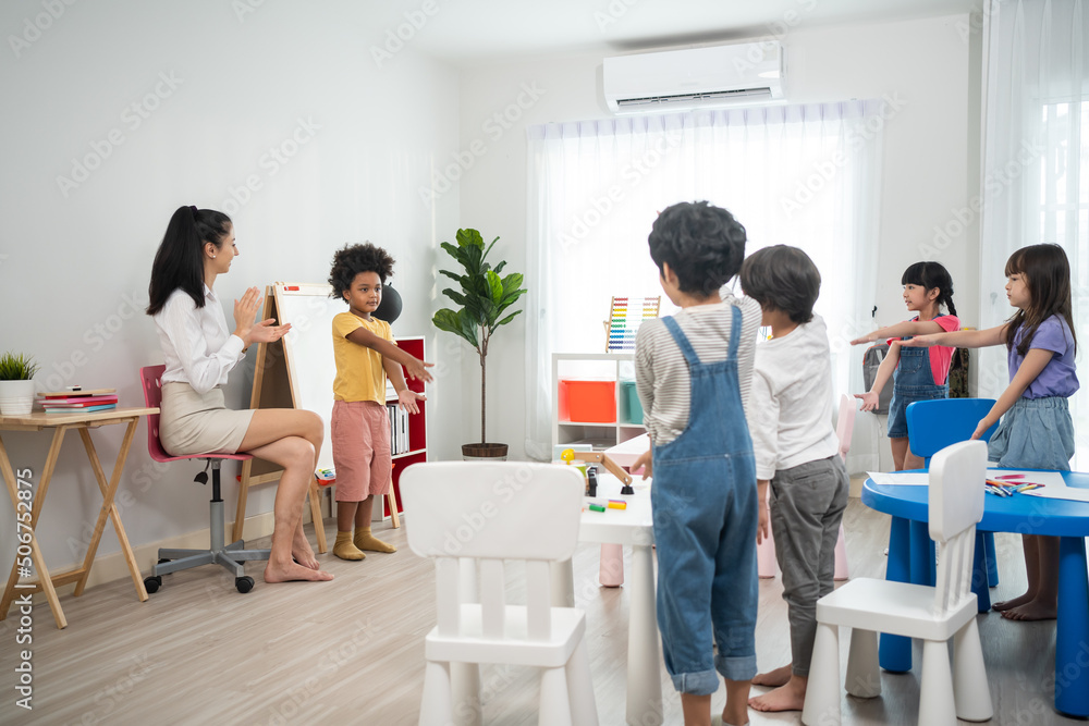Caucasian beautiful woman teacher doing activity with kids at school ...