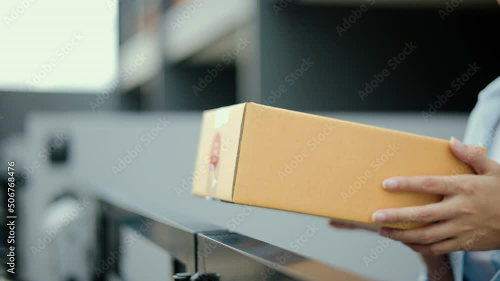 Close up parcel in hand of blue uniform delivery man to customer front ...