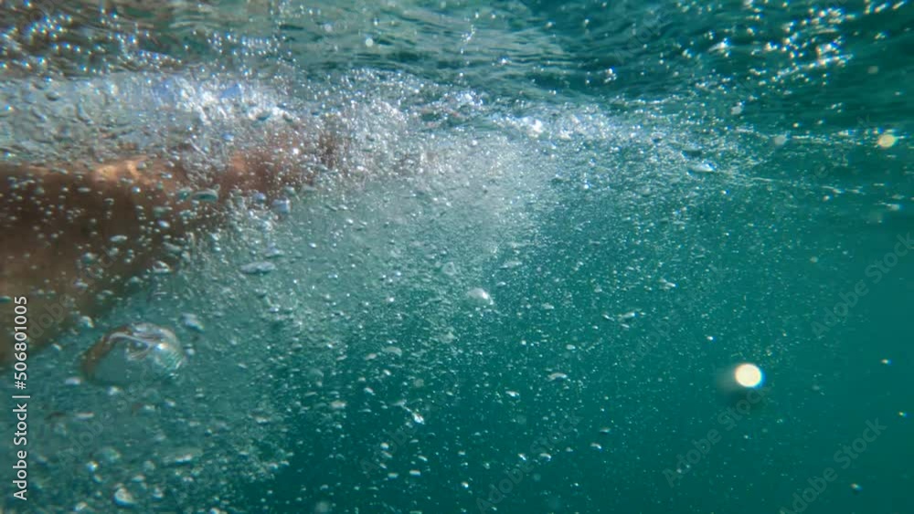 Male swimmer hand underwater making air bubbles, man drowning in sea ...