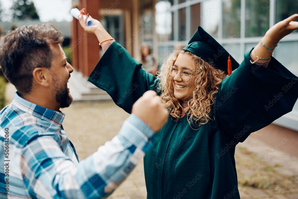 Happy graduate student celebrates graduation day with her father after ...