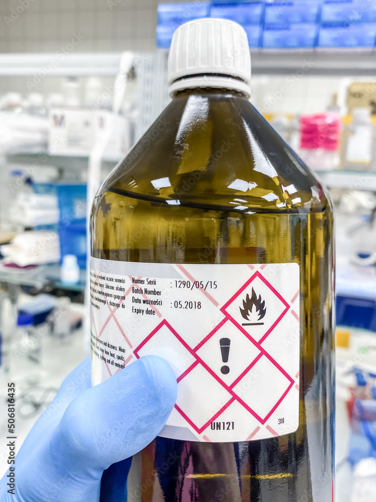 A glass bottle of highly flammable liquid chemical reagent in a ...