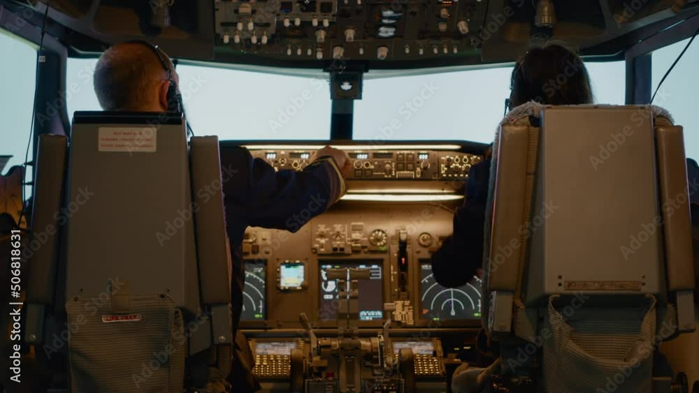 Plane captain and woman copilot fixing altitude on dashboard, using ...