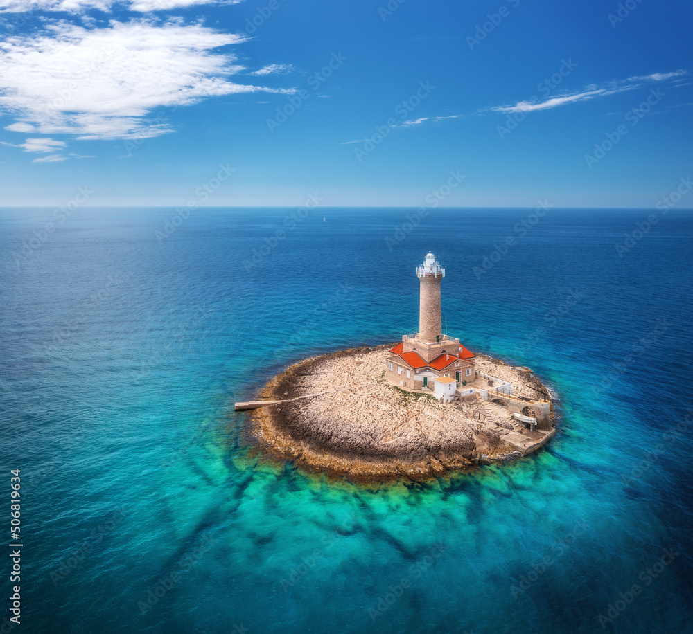 Lighthouse on smal island in the sea at sunny day in summer. Aerial top ...