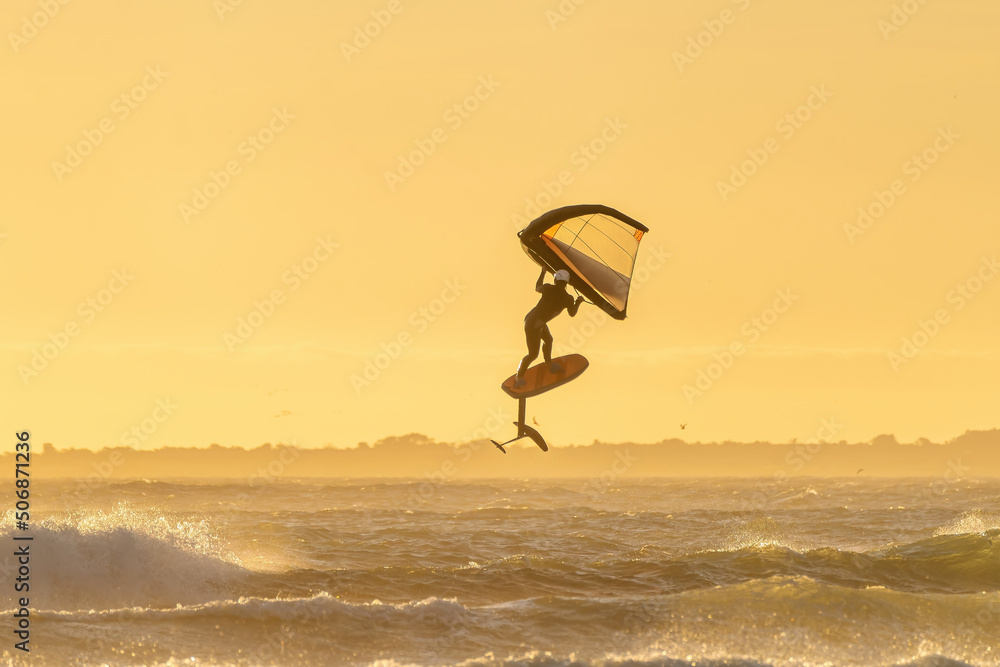 Focus on jump with wing foil equipment over a big ocean wave during ...