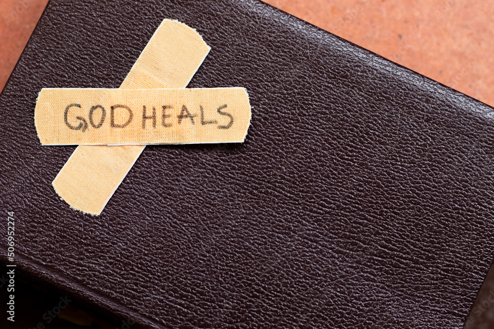 God heals, a handwritten message text on a bandage tape with closed ...