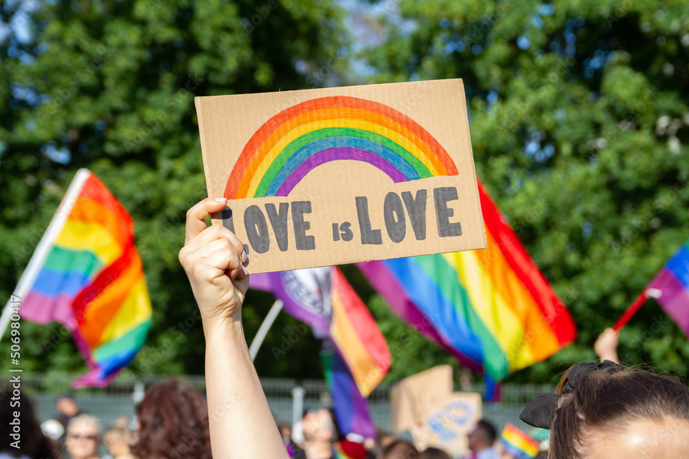 Woman holding placard sign Love is Love with rainbow symbol of LGBT ...