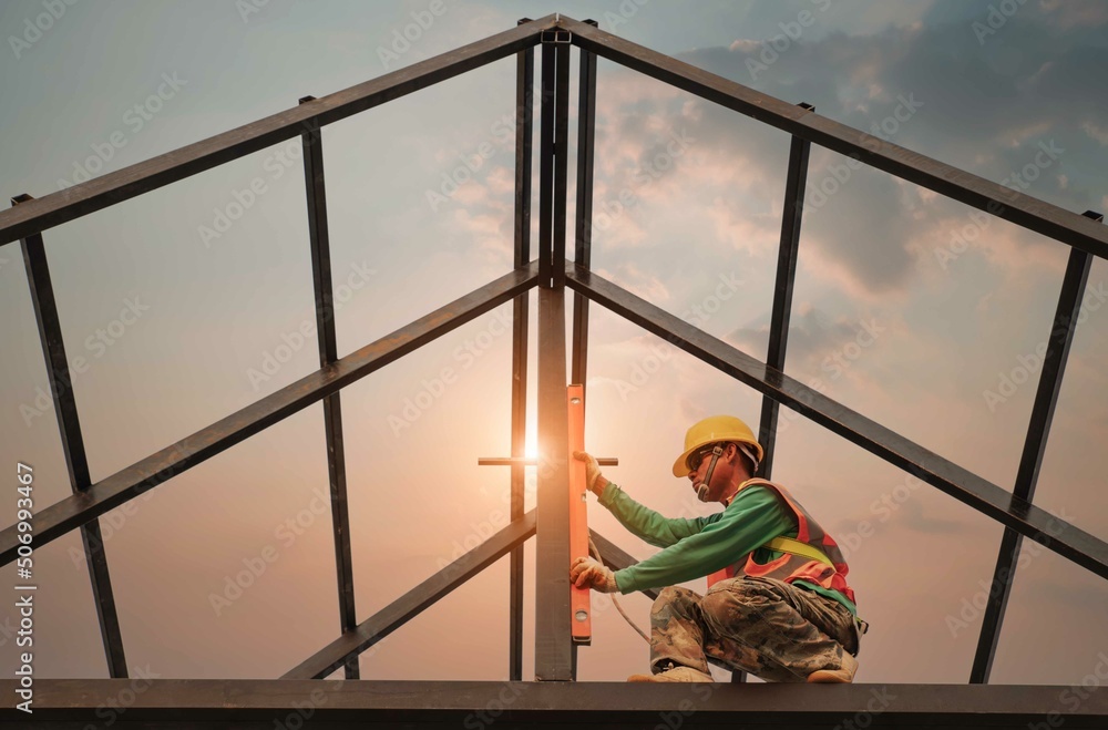 Construction workers wear safety belts during work on building roof ...