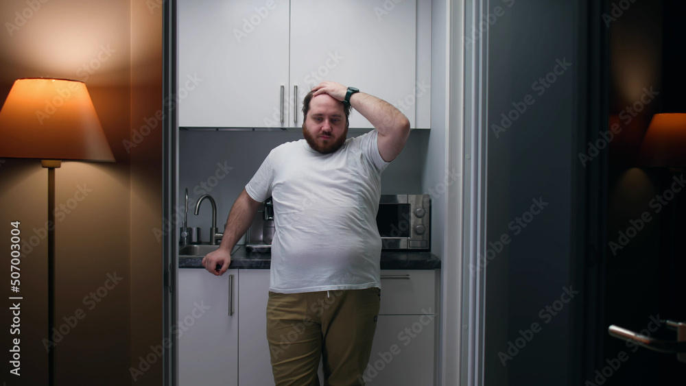Portrait of frustrated overweight man stand in small kitchen Stock ...