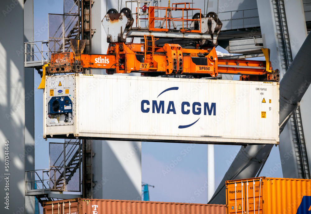 Crane operator unloading a refrigerated container from a cargo ship the ...