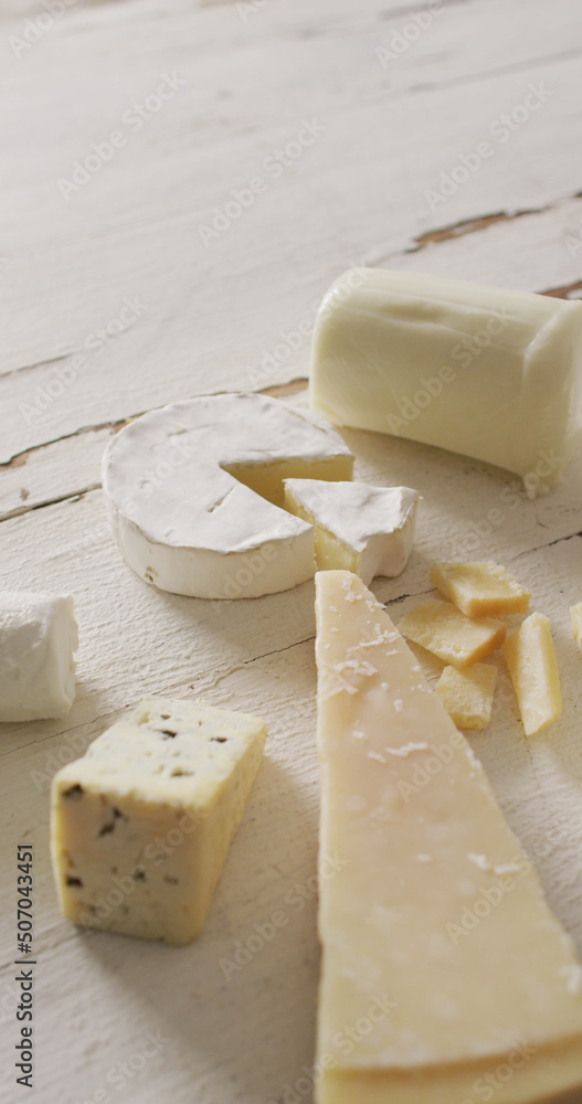 Vertical image of few types of cheese on white rustic background Stock ...