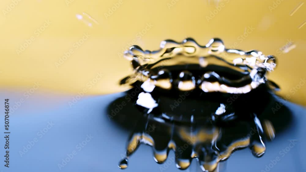 Close up real of water drop falls into water and diverging circles of ...