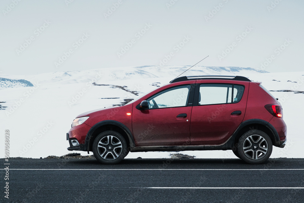 Side view of a red colored Dacia brand Sandero model car paused on an ...
