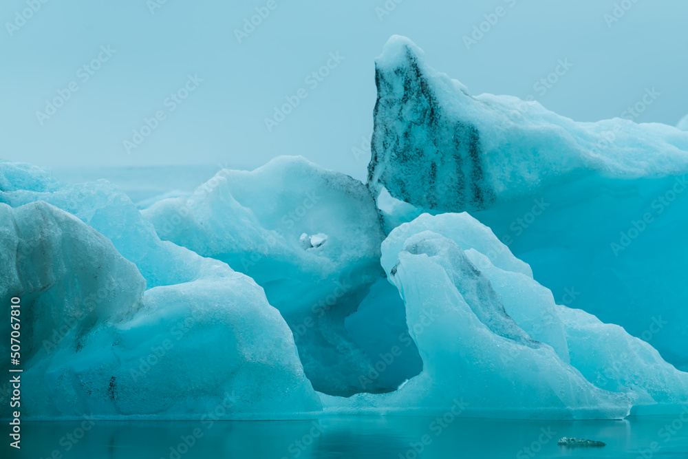 Close-up of abstract formation of blue melting glacier ice with black ...