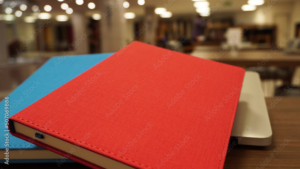 Blue and red notebooks on the desk in the school student library. Stock ...