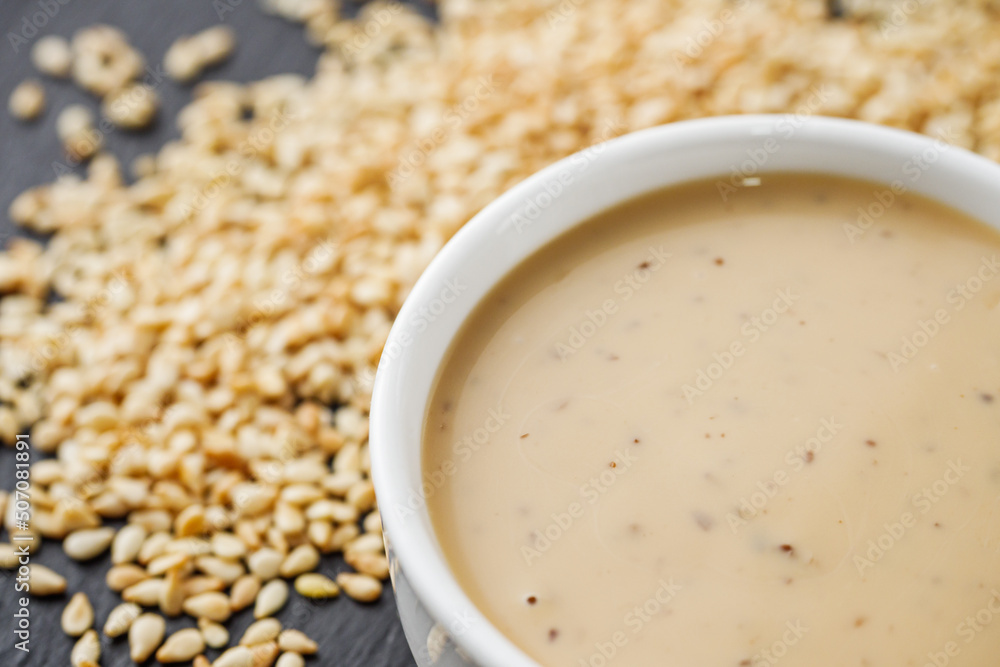 sesame tahini paste on a black stone background Stock Photo | Adobe Stock