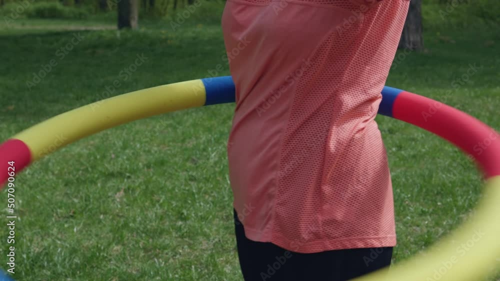 close-up hula hoop exercises on belly outdoor, hula-hoop twirling for ...