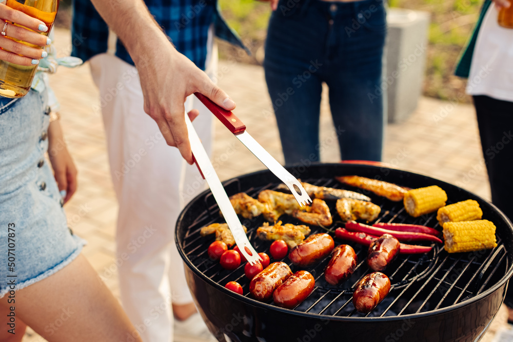 man prepares a barbecue for friends, happy friends make a barbecue ...