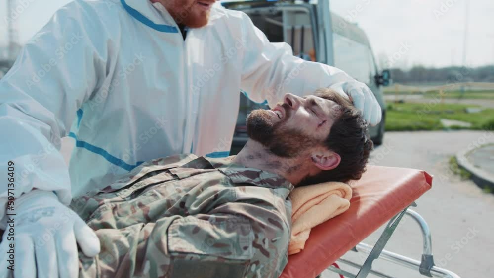 Close-up footage of men in uniforms for field doctors providing first ...