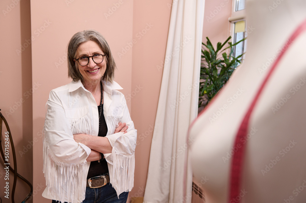 Elegant mature European woman dressmaker, fashion designer, smiling ...