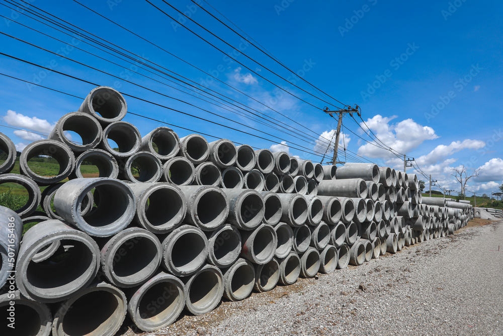 Stack of concrete drainage pipes for wells and water discharges with ...