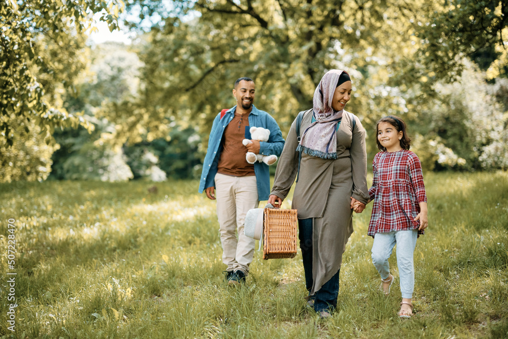 Happy Muslim family walks through nature while going on picnic. Stock ...