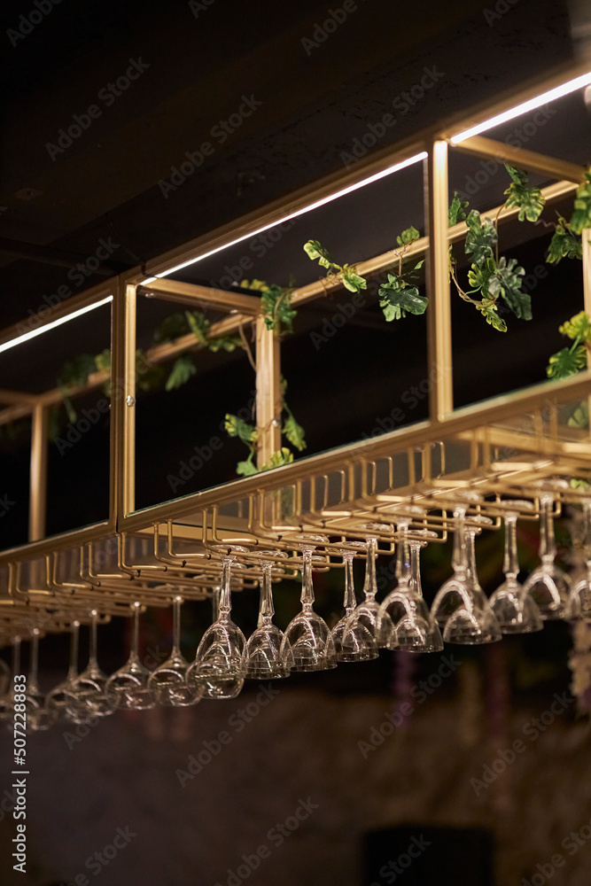 glasses hang over the bar in the restaurant. champagne glasses hanging ...