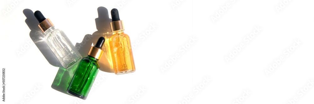 banner three glass bottles with pipettes with beautiful sun shadows ...