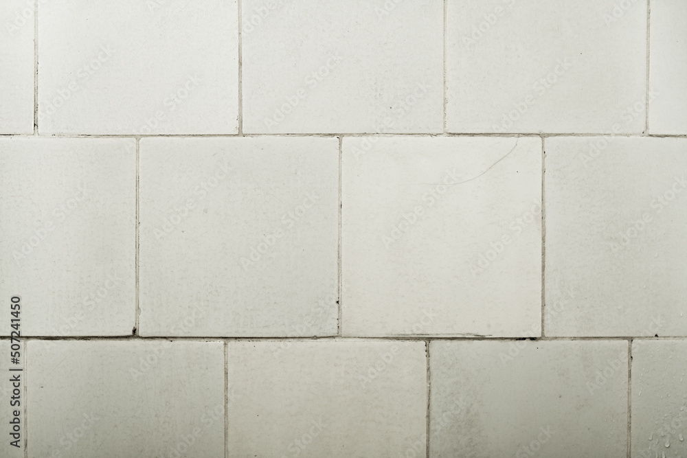 Old style bathroom wall decorated with square ceramic tile. Old white ...