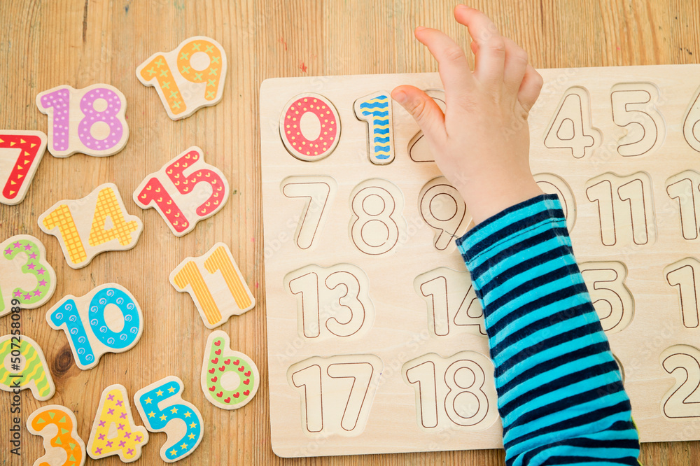 Kid learning numbers through game. Activity with wooden numbers ...
