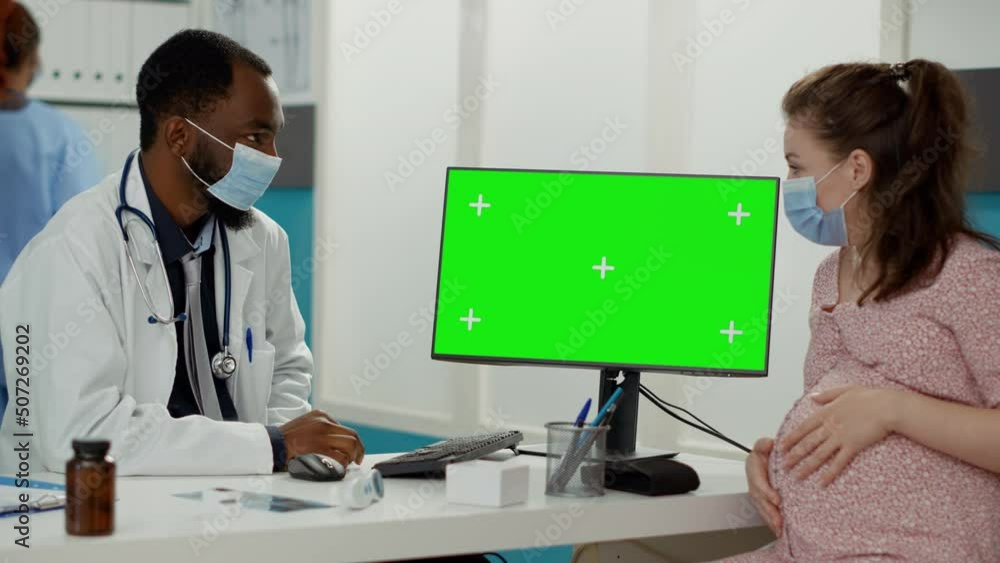 People with face mask using computer with greenscreen at pregnancy ...