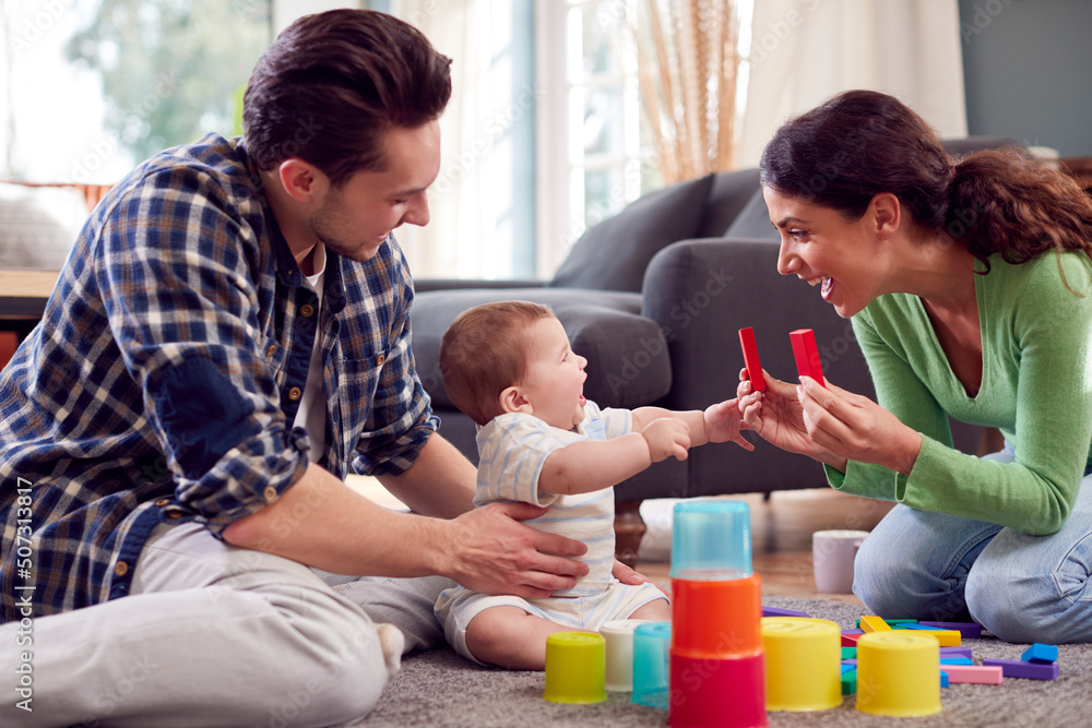 Transgender Family With Baby Playing Game With Colourful Toys In Lounge ...
