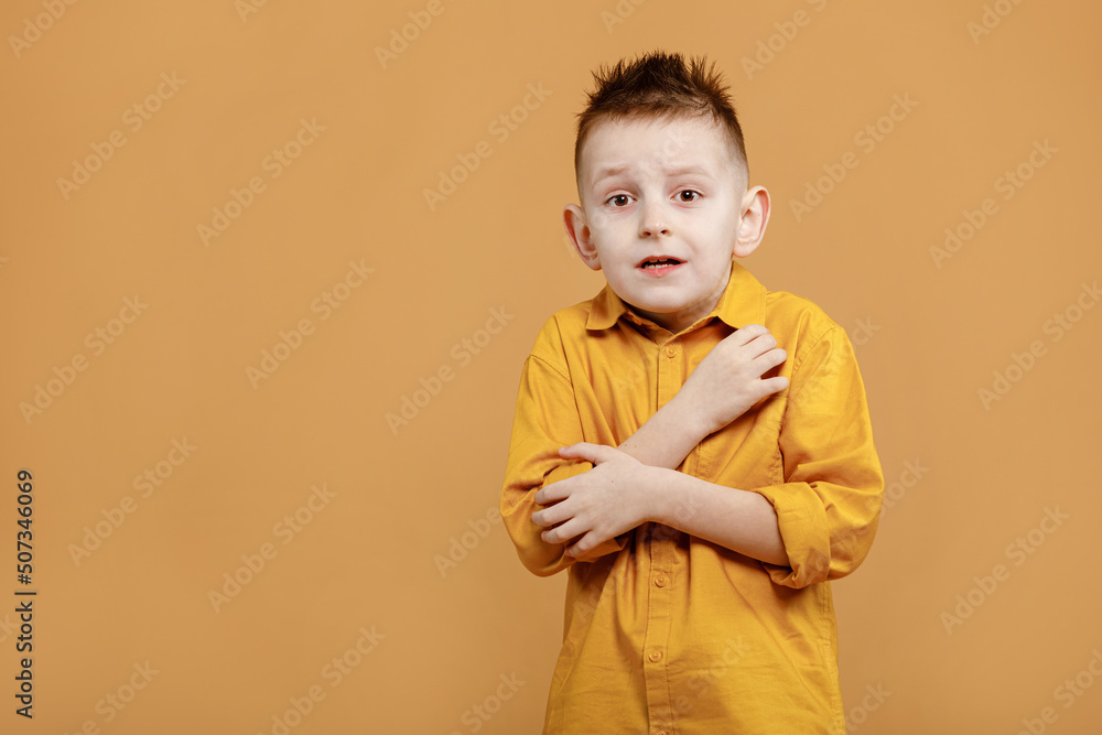 portrait of caucasian scared child boy on yellow background. amazed ...