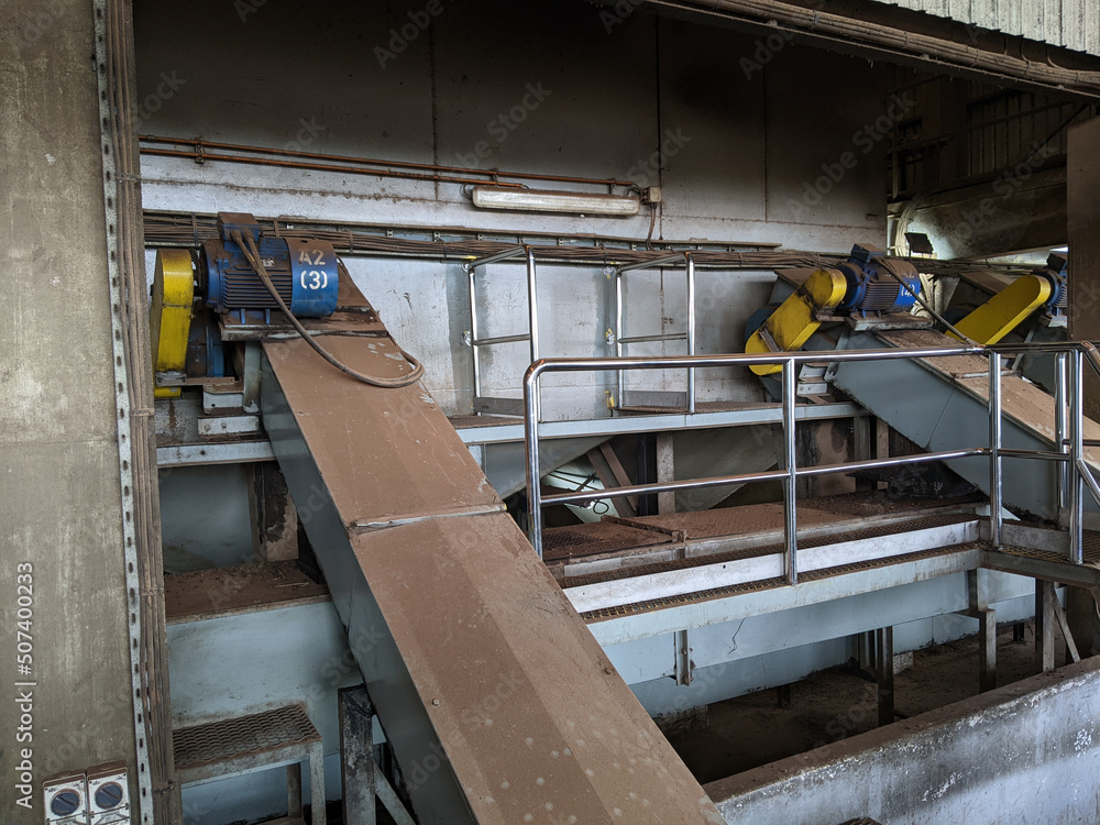 Malaysia, 25 May 2022: A blue palm kernel intake conveyor motor located ...