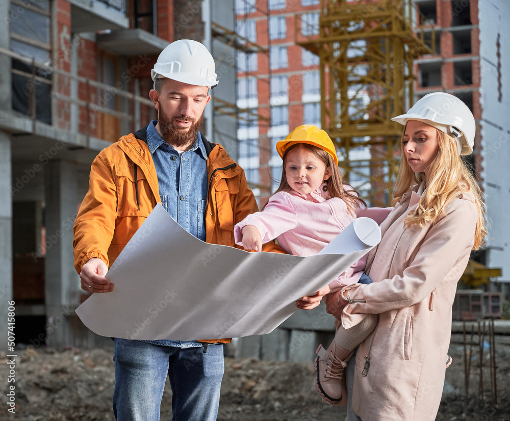 Family with child studying architectural drawings outside apartment ...