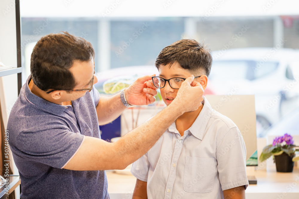 Indian father and son choosing eyeglasses in optics store, Portrait of ...