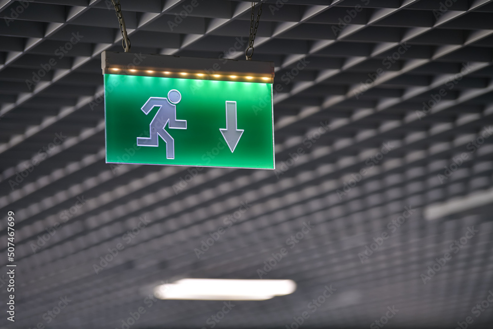 Emergency exit sign on the ceiling of a new modern office company ...